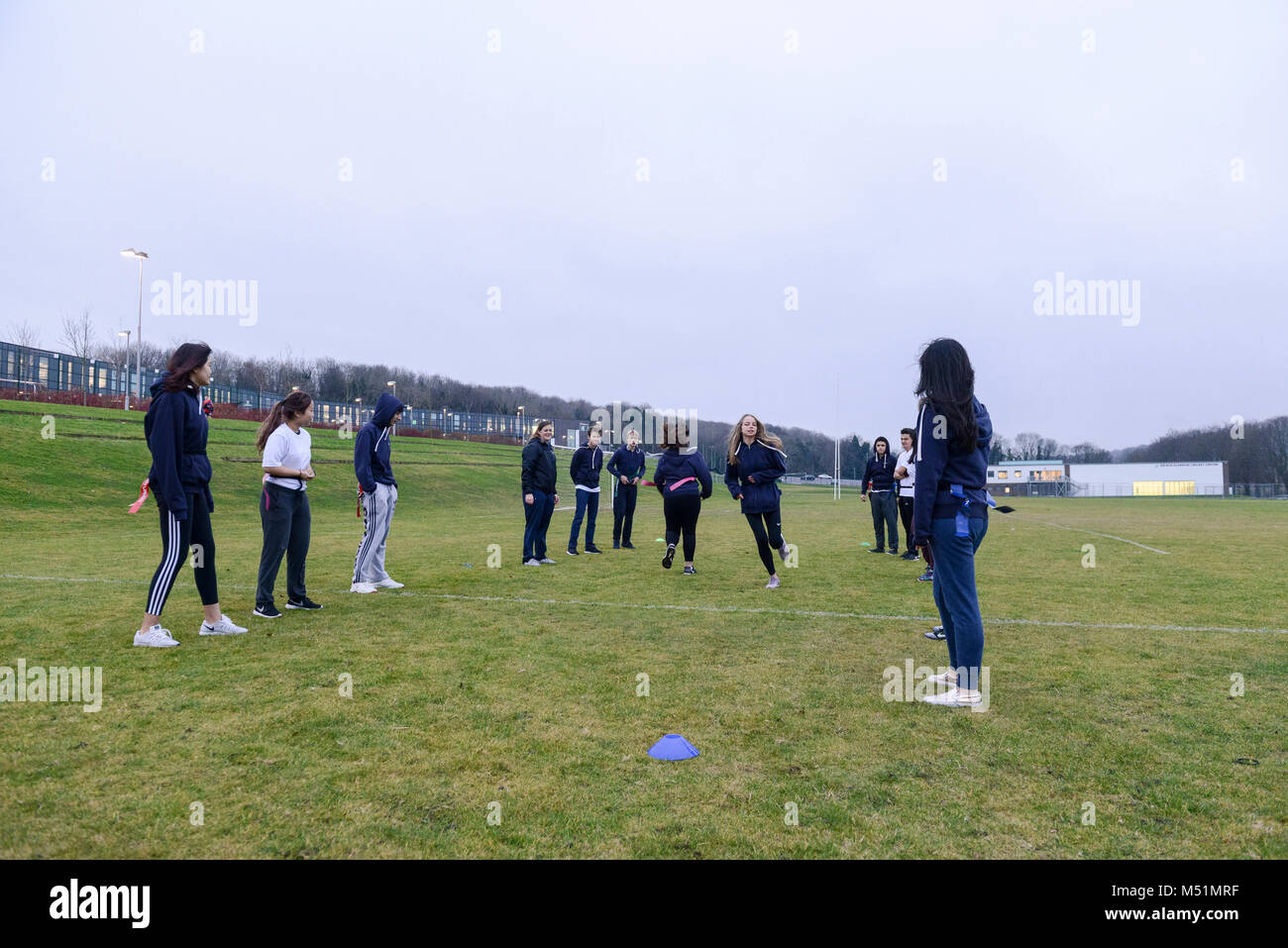 school students having a football lesson to improve their skills at ...
