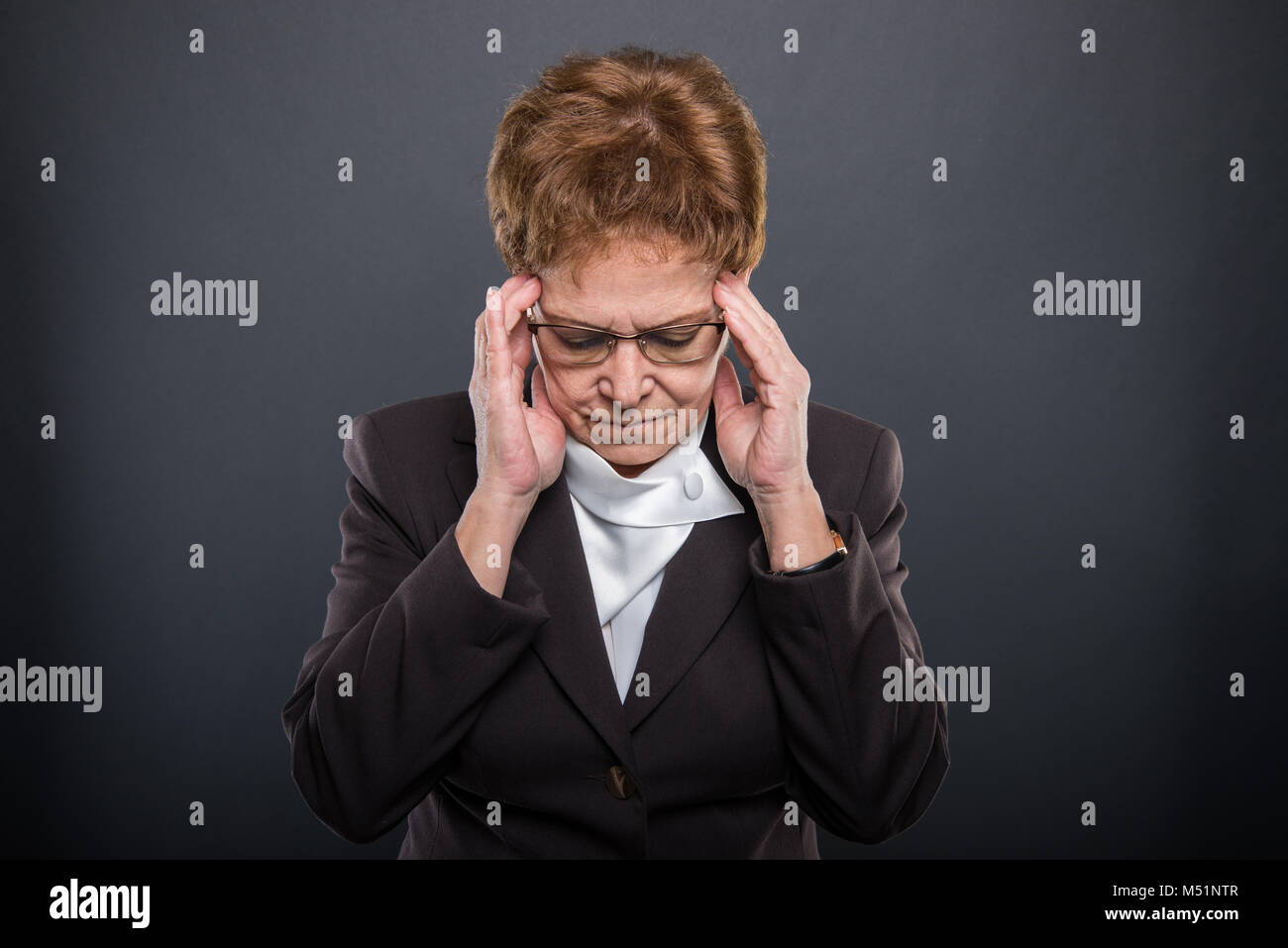 Business senior lady holding head like concentrating on black ...