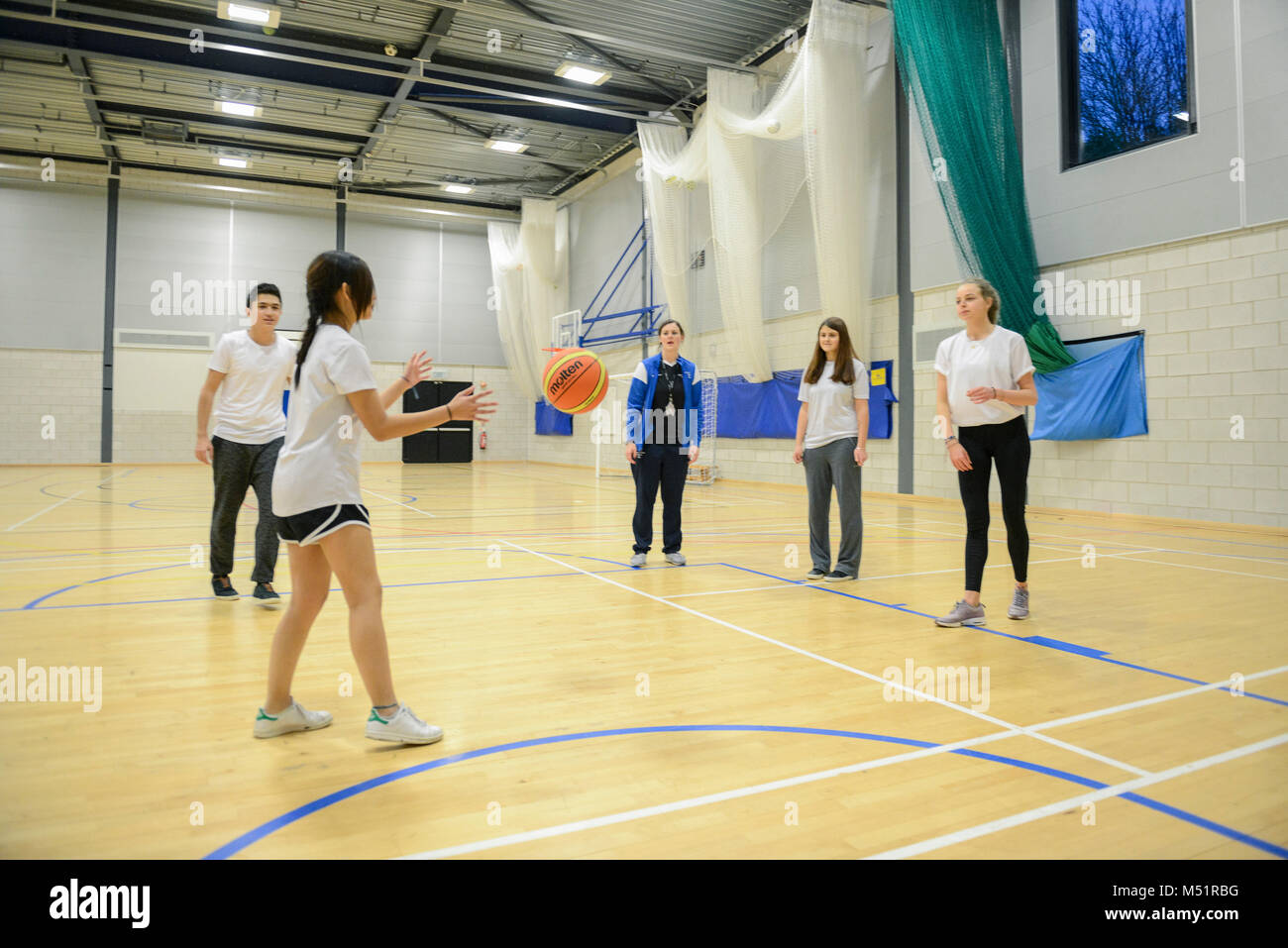 school students playing sports in the indoor sports hall at their ...
