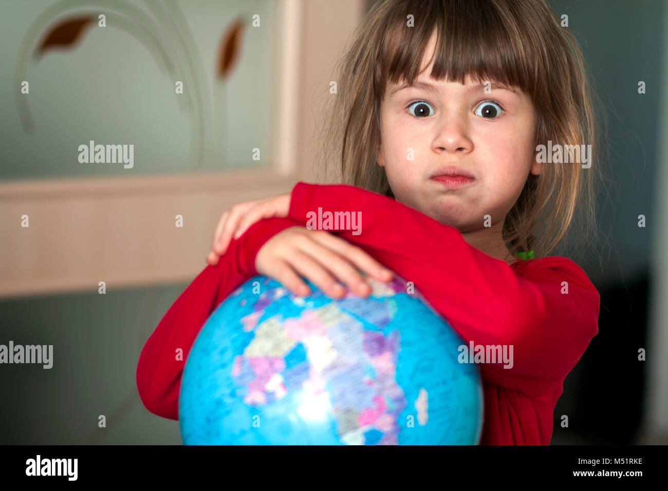 Portrait of the cute little girl hugging the earth globe. Education and ...