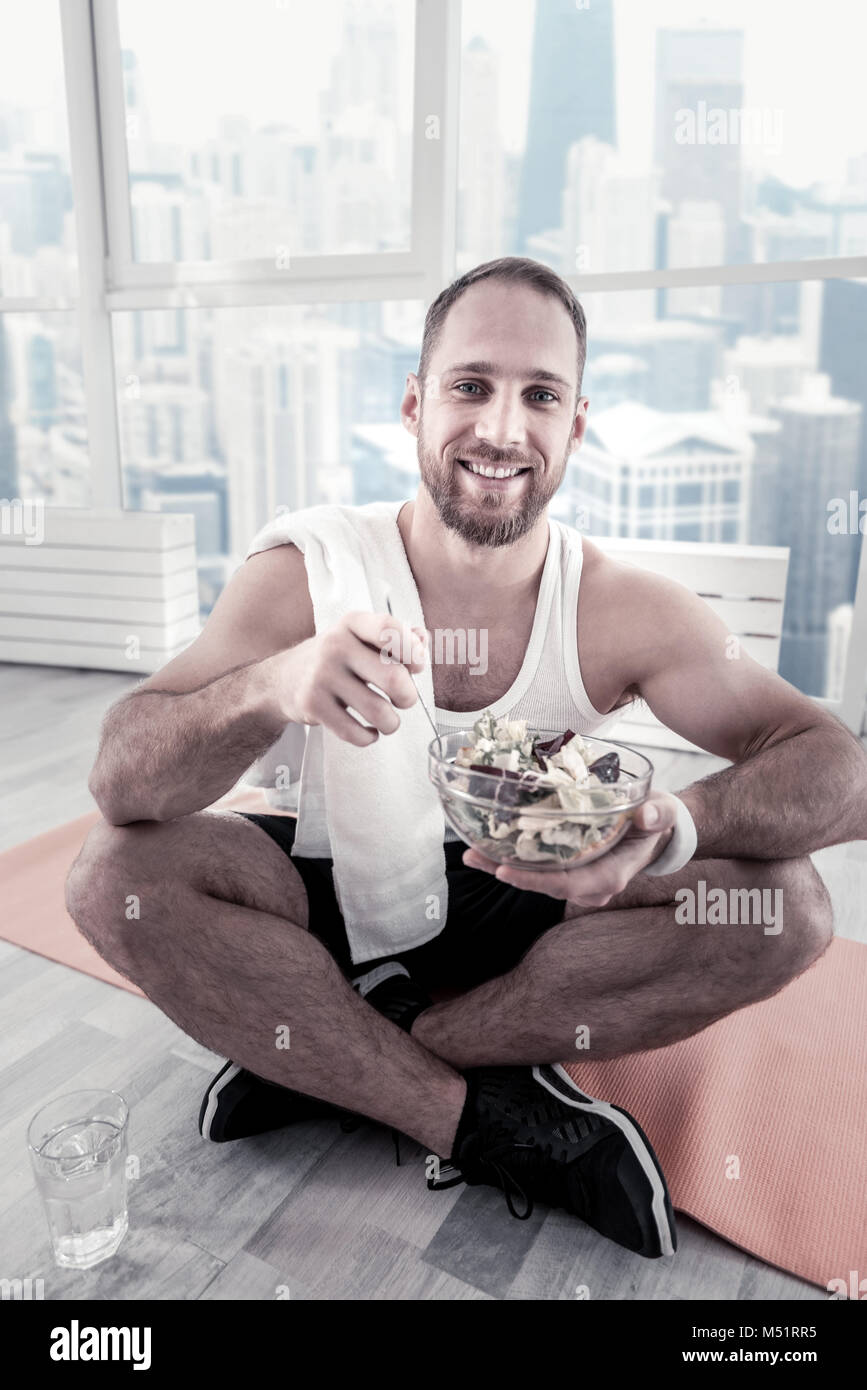 Inspired experienced sportsman eating salad Stock Photo - Alamy
