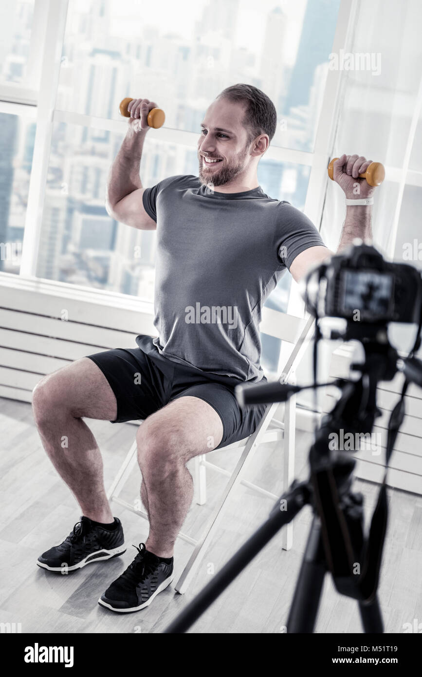 Vigorous male blogger performing arms workout Stock Photo - Alamy