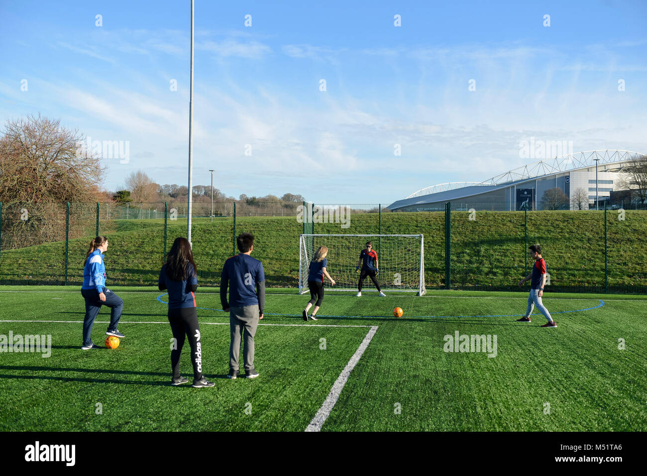 school students having a football lesson to improve their skills at ...
