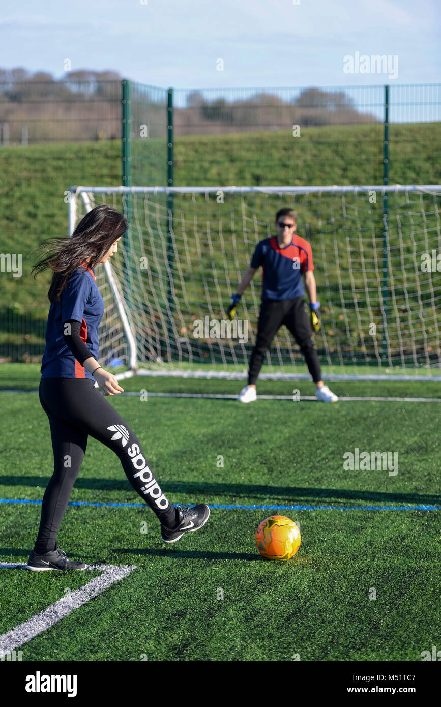 school students having a football lesson to improve their skills at ...