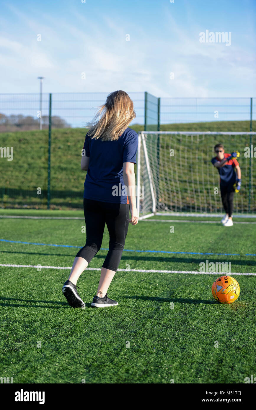 school students having a football lesson to improve their skills at ...
