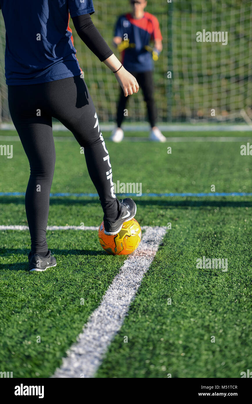 school students having a football lesson to improve their skills at ...