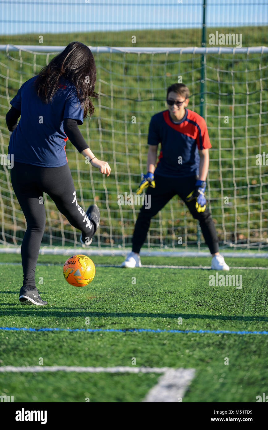 school students having a football lesson to improve their skills at ...