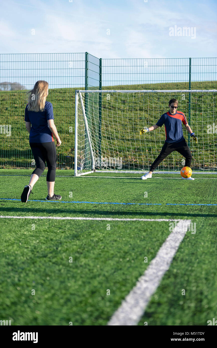 school students having a football lesson to improve their skills at ...