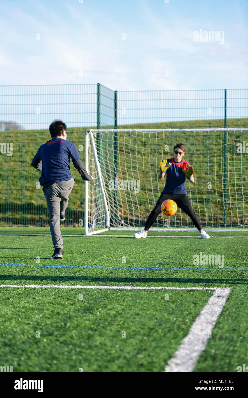 school students having a football lesson to improve their skills at ...