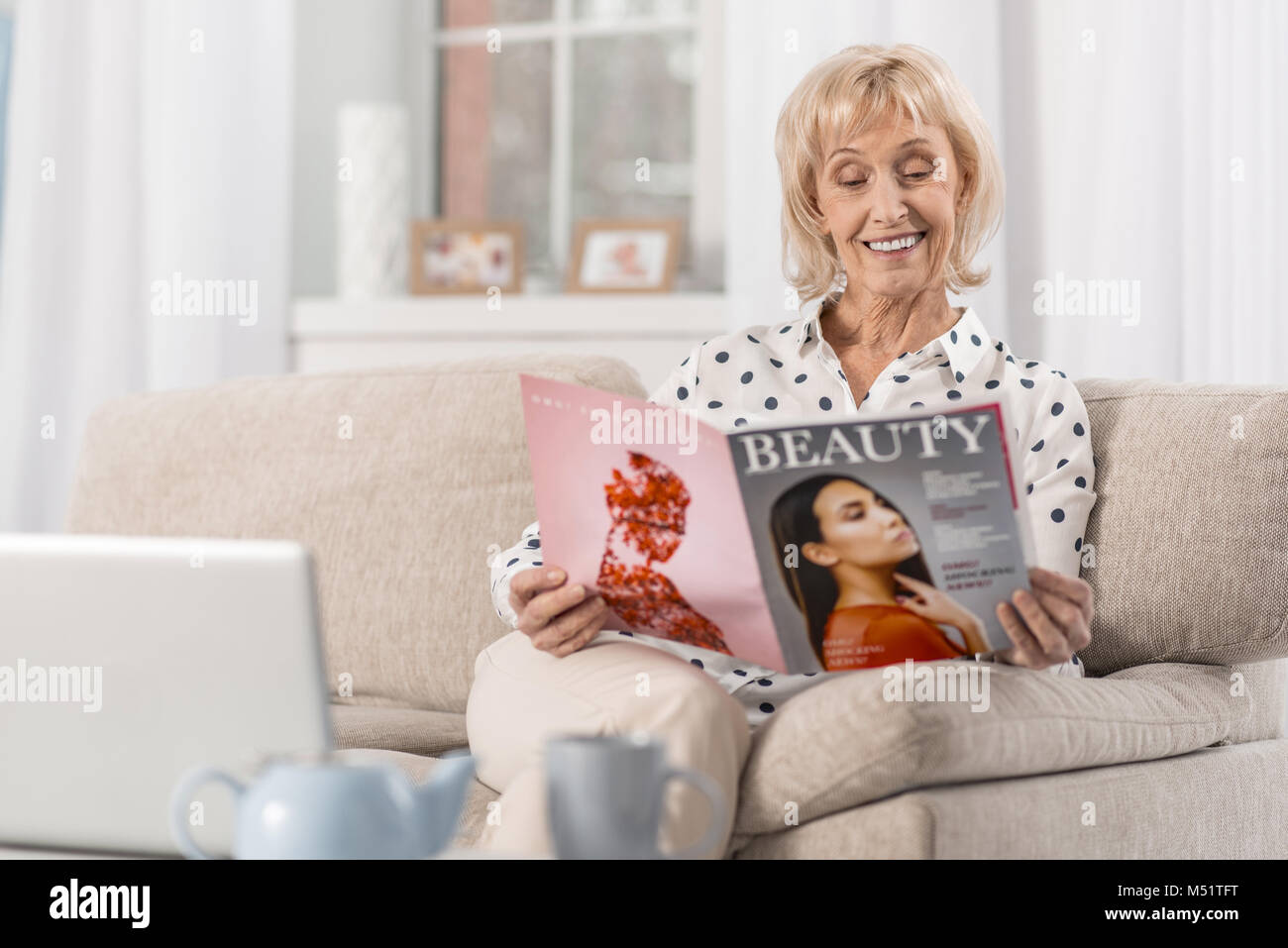 Gay mature woman reading magazine Stock Photo - Alamy