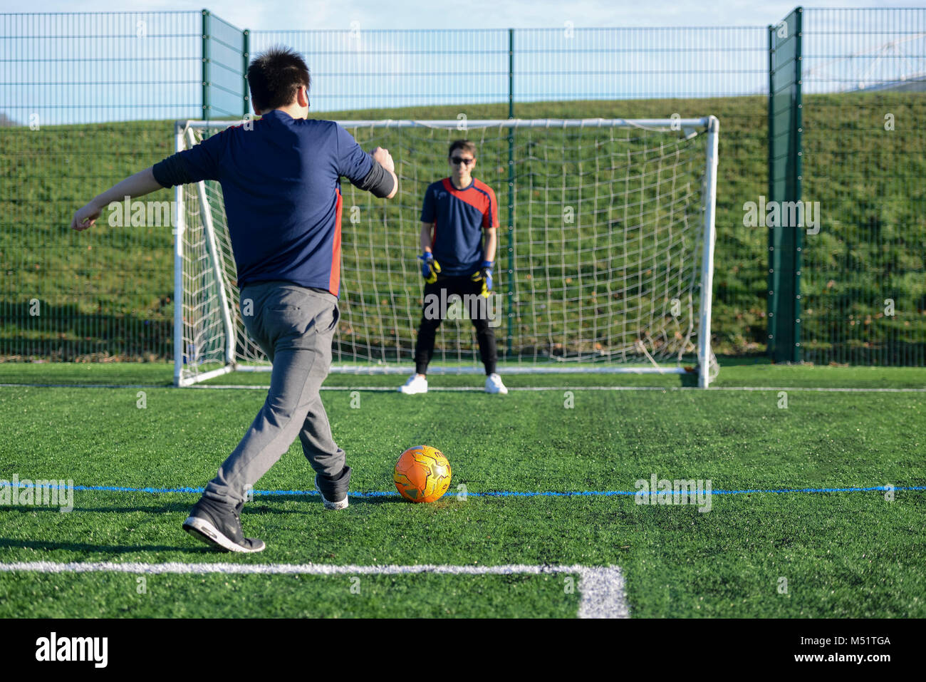 school students having a football lesson to improve their skills at ...