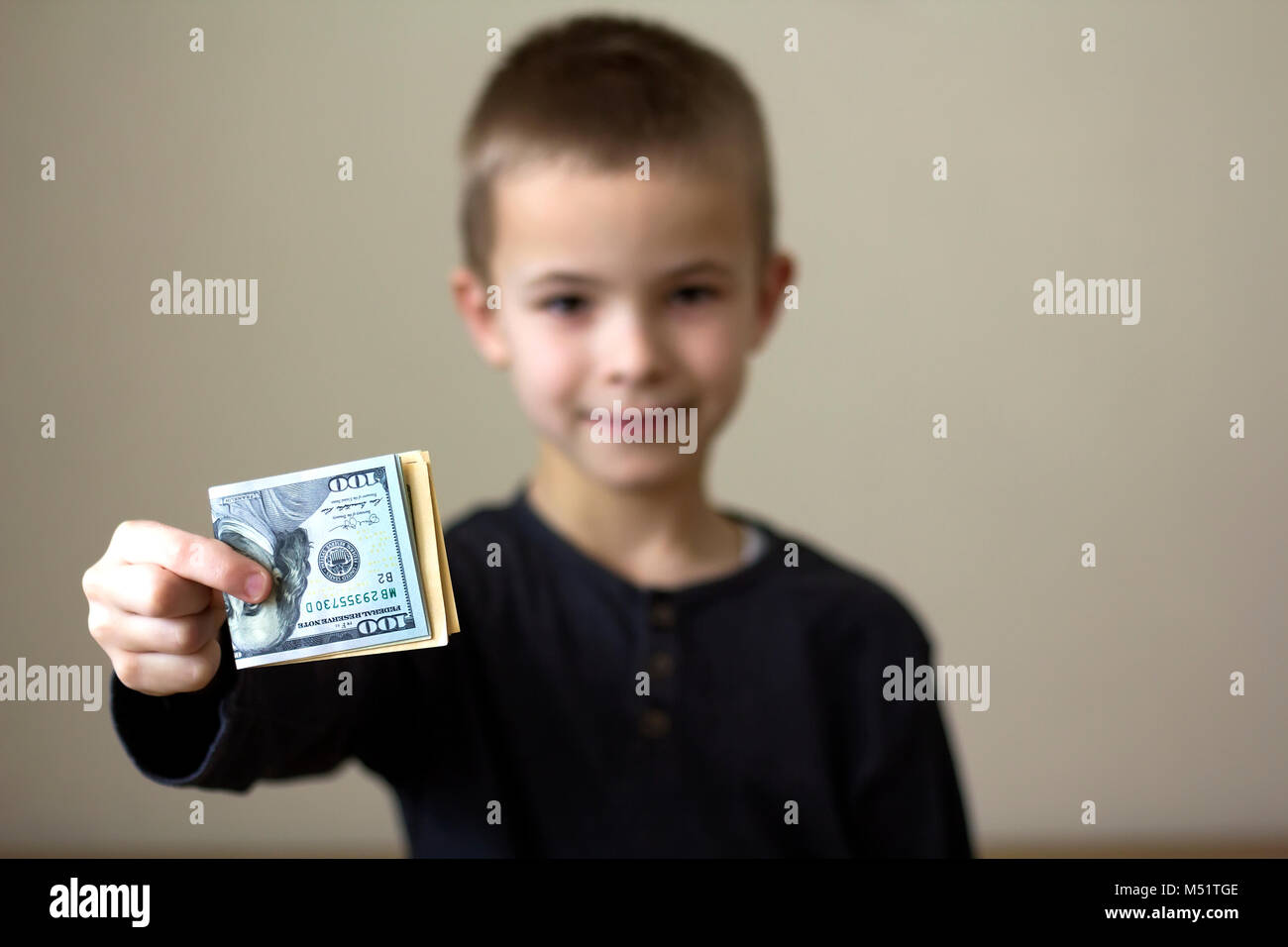Cheerful blurred boy showing american dollars money Stock Photo - Alamy