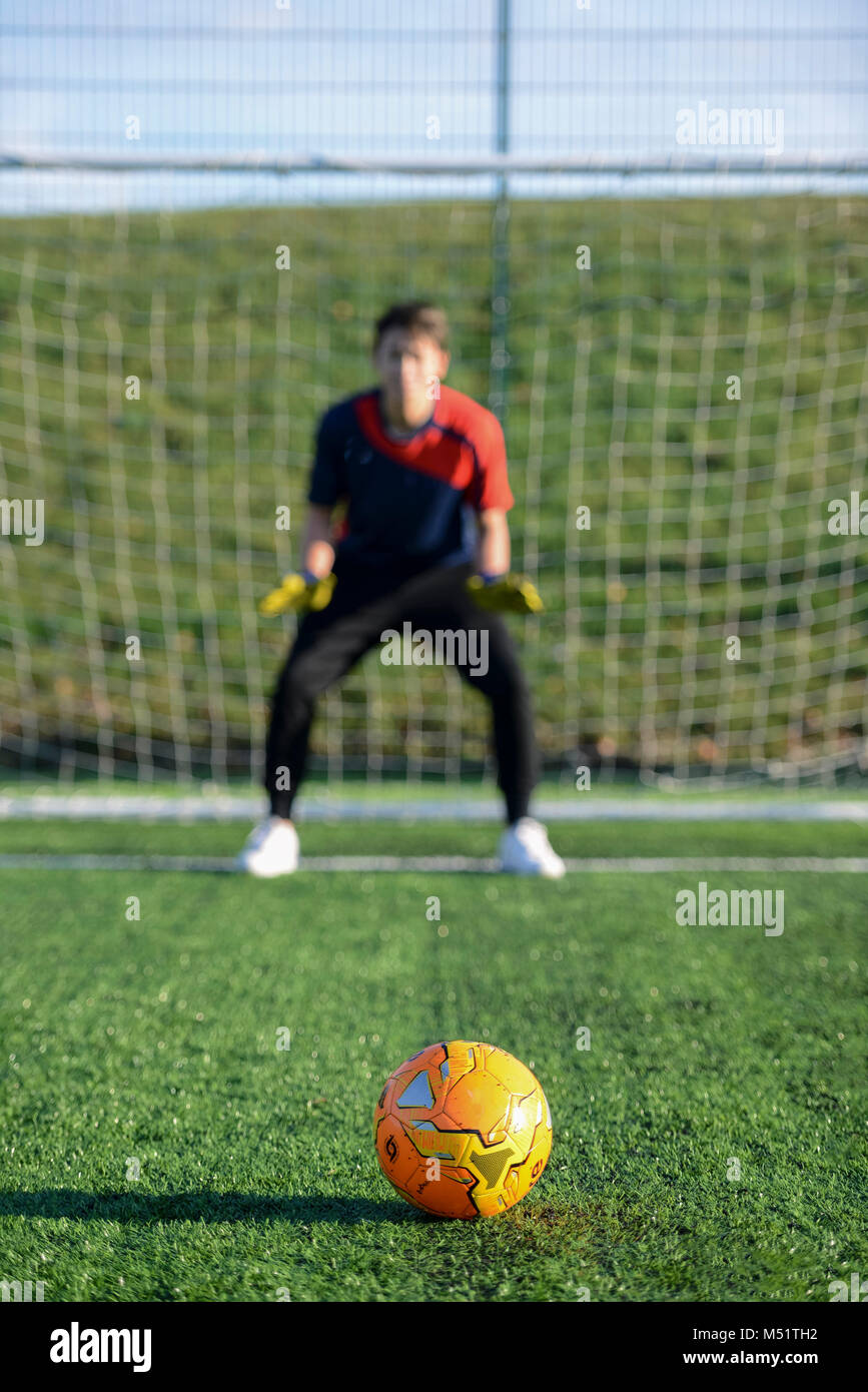 school students having a football lesson to improve their skills at ...