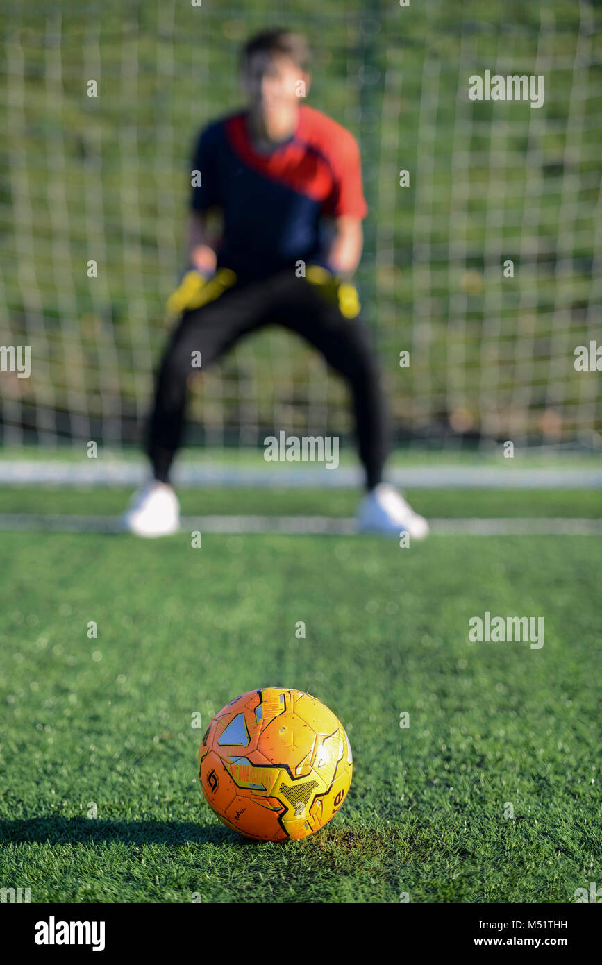 school students having a football lesson to improve their skills at ...