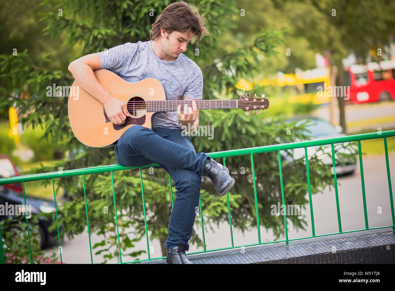 Young man playing guitar outdoors Stock Photo - Alamy