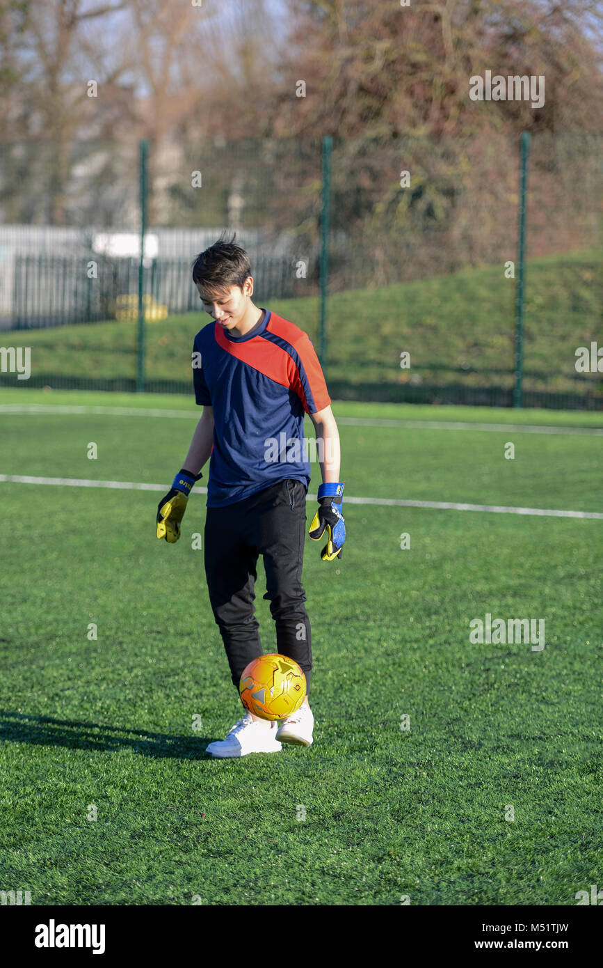 school students having a football lesson to improve their skills at ...