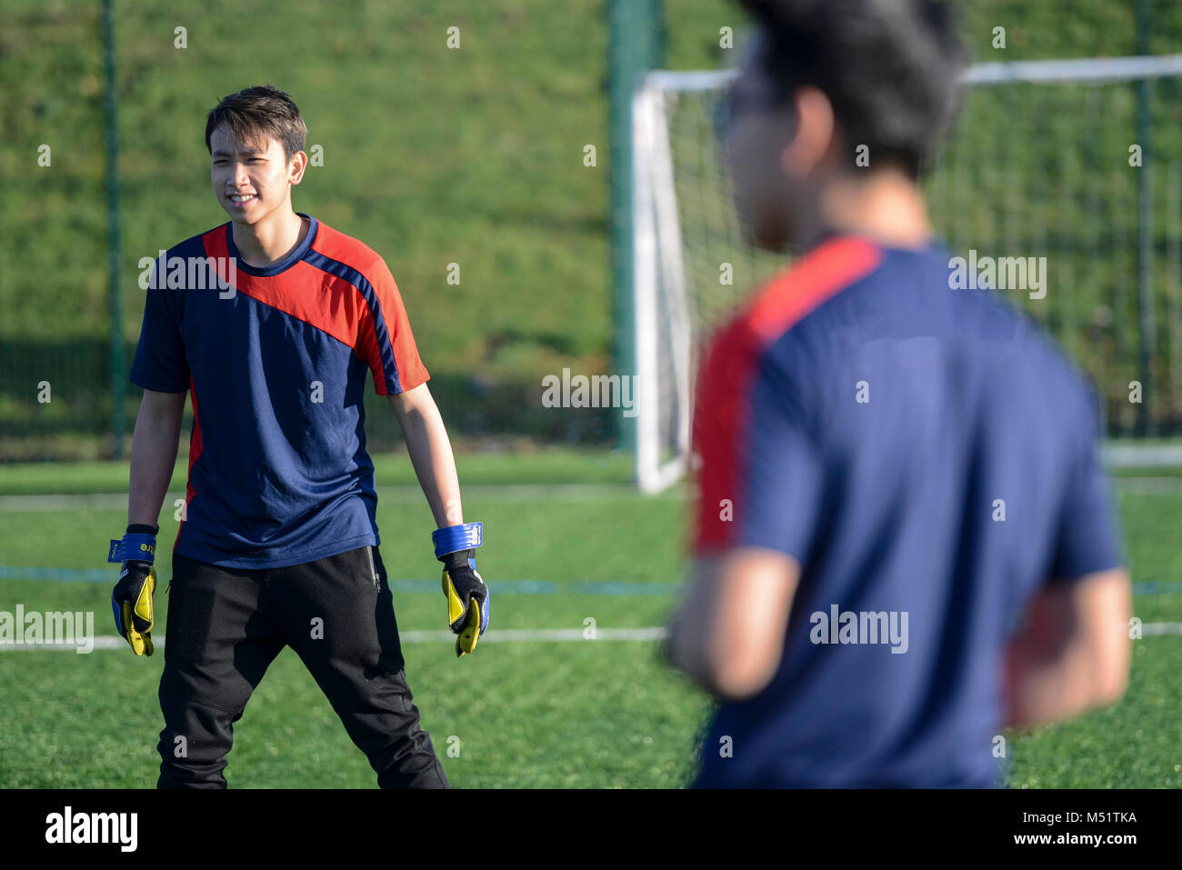school students having a football lesson to improve their skills at ...