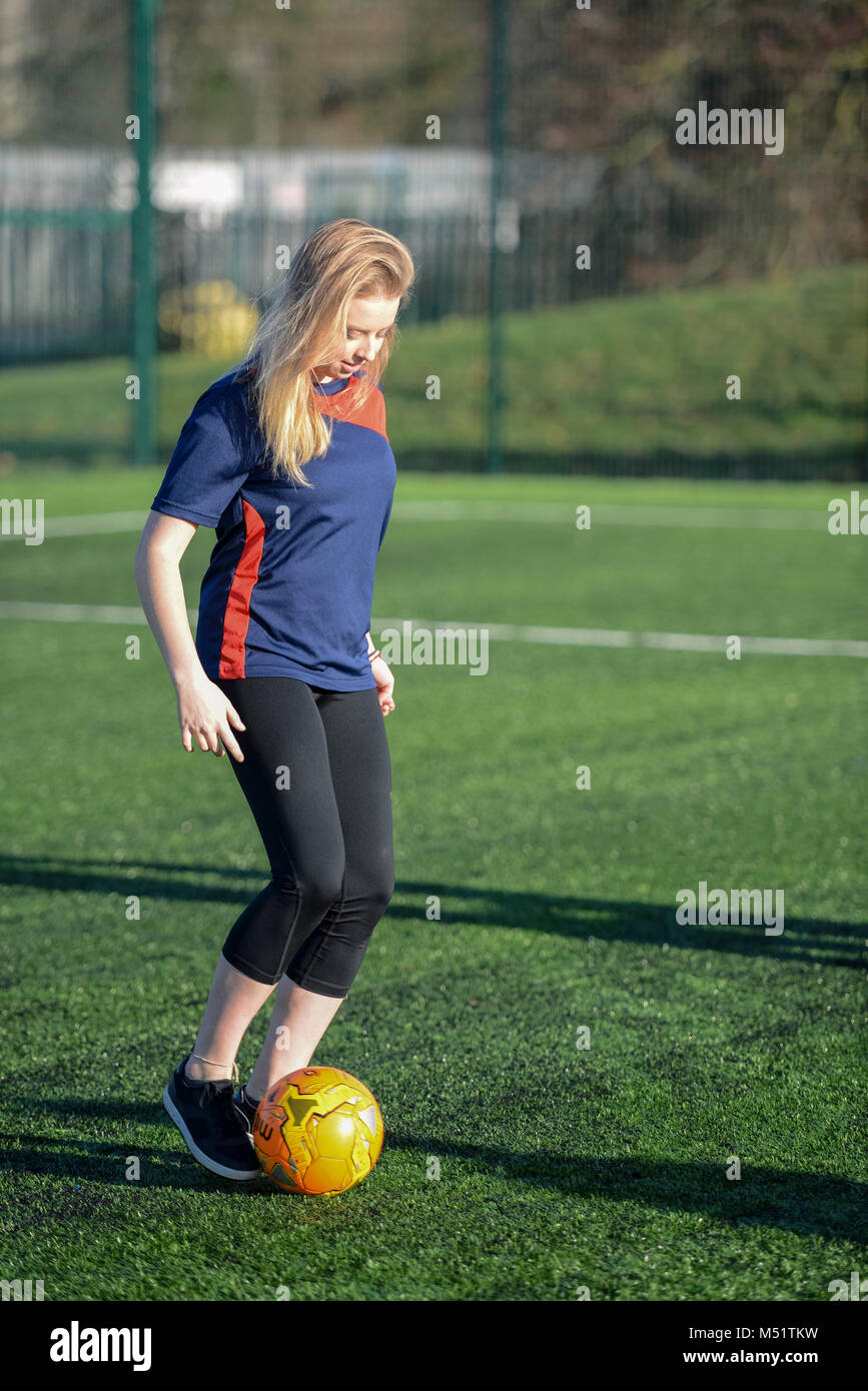 school students having a football lesson to improve their skills at ...