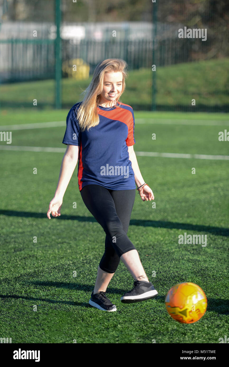 school students having a football lesson to improve their skills at ...