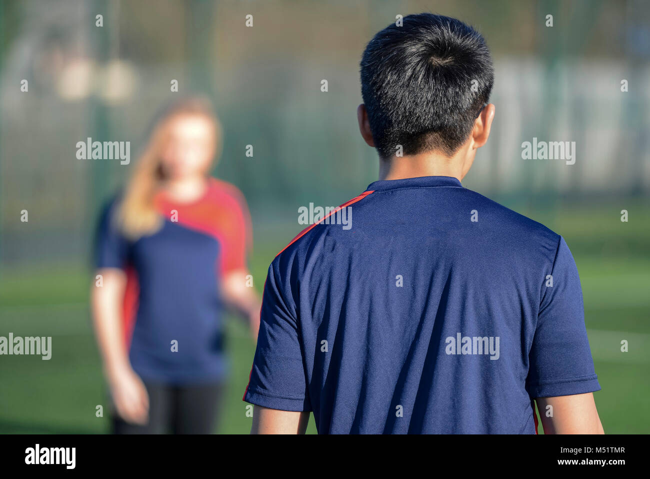 school students having a football lesson to improve their skills at ...