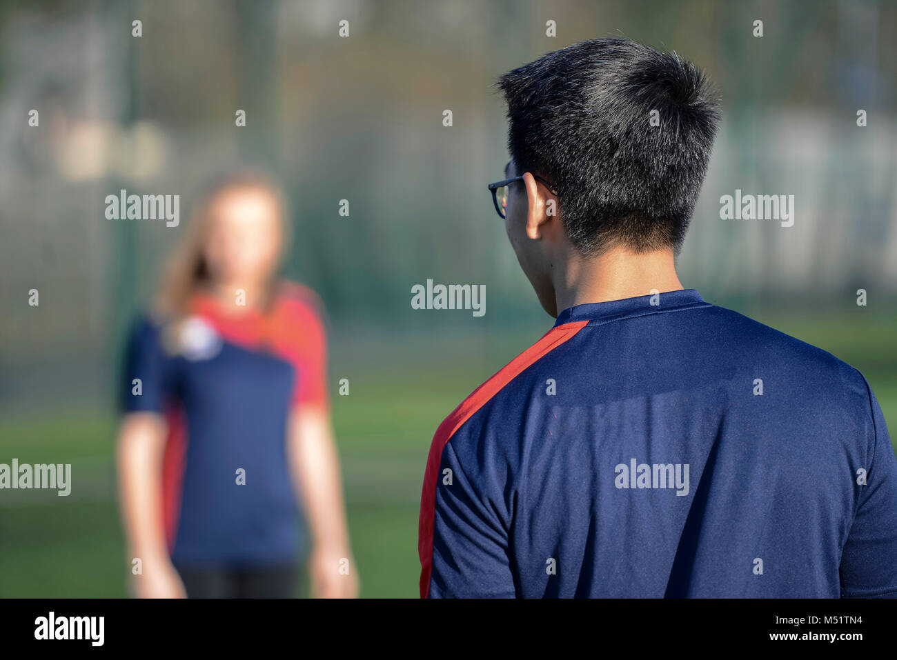 school students having a football lesson to improve their skills at ...