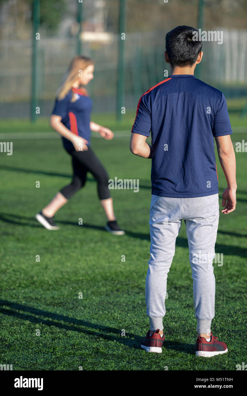 school students having a football lesson to improve their skills at ...