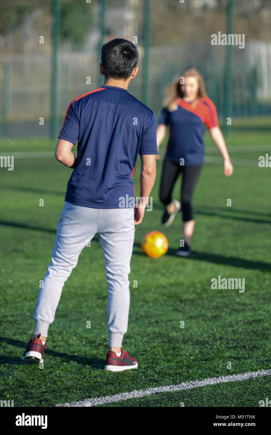 school students having a football lesson to improve their skills at ...