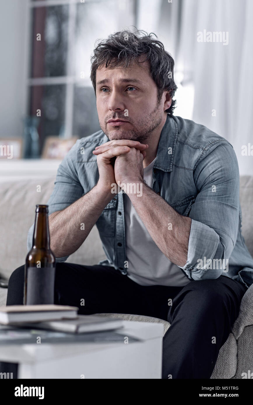 Unhappy divorced man sitting alone and thinking about his wife Stock ...