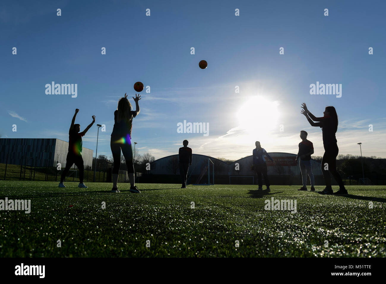 school students having a football lesson to improve their skills at ...