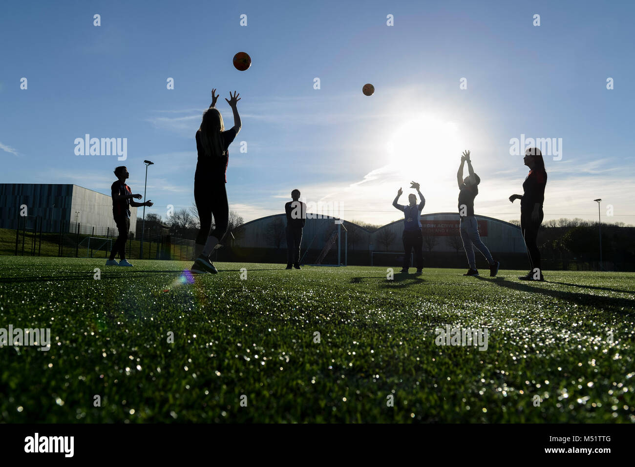 school students having a football lesson to improve their skills at ...