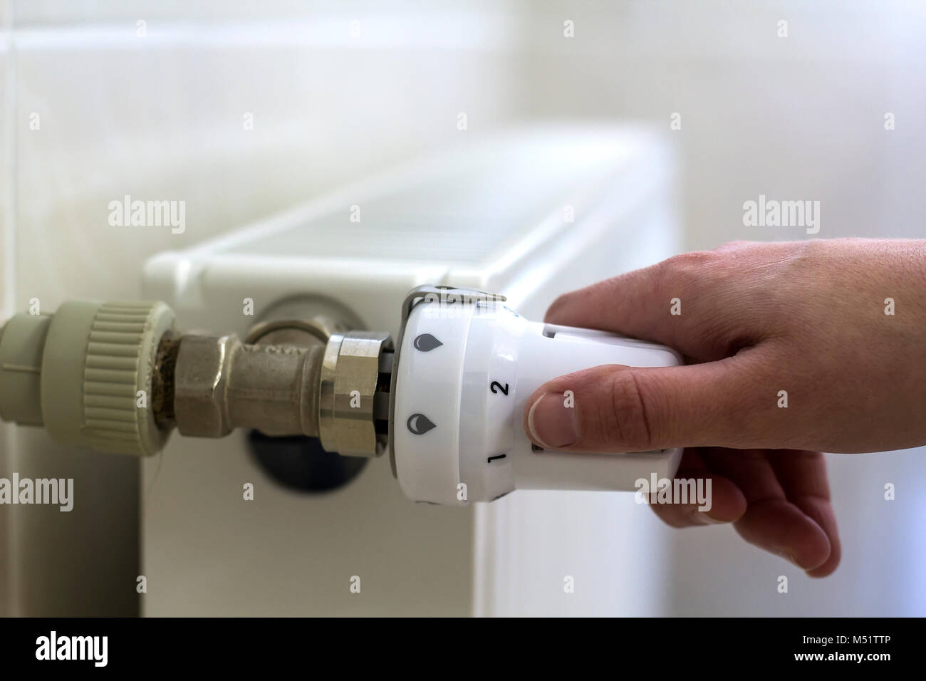 Hand adjusting the valve knob thermostat of heating radiator Stock ...