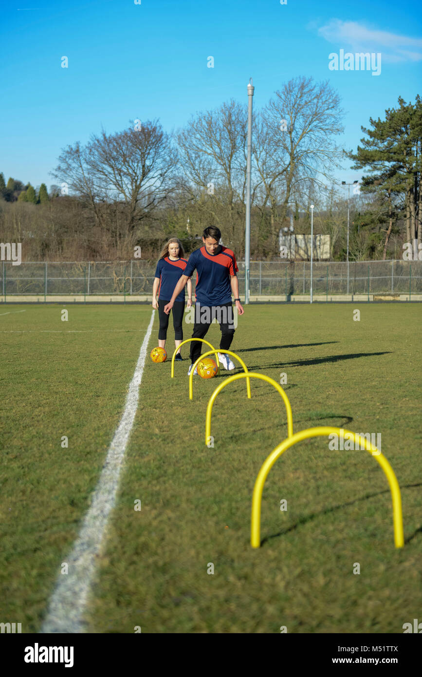 school students having a football lesson to improve their skills at ...