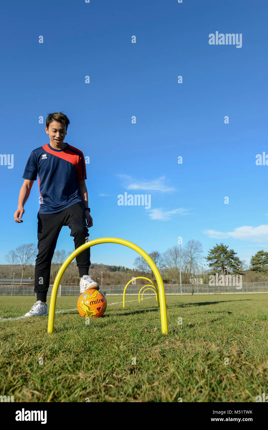 school students having a football lesson to improve their skills at ...