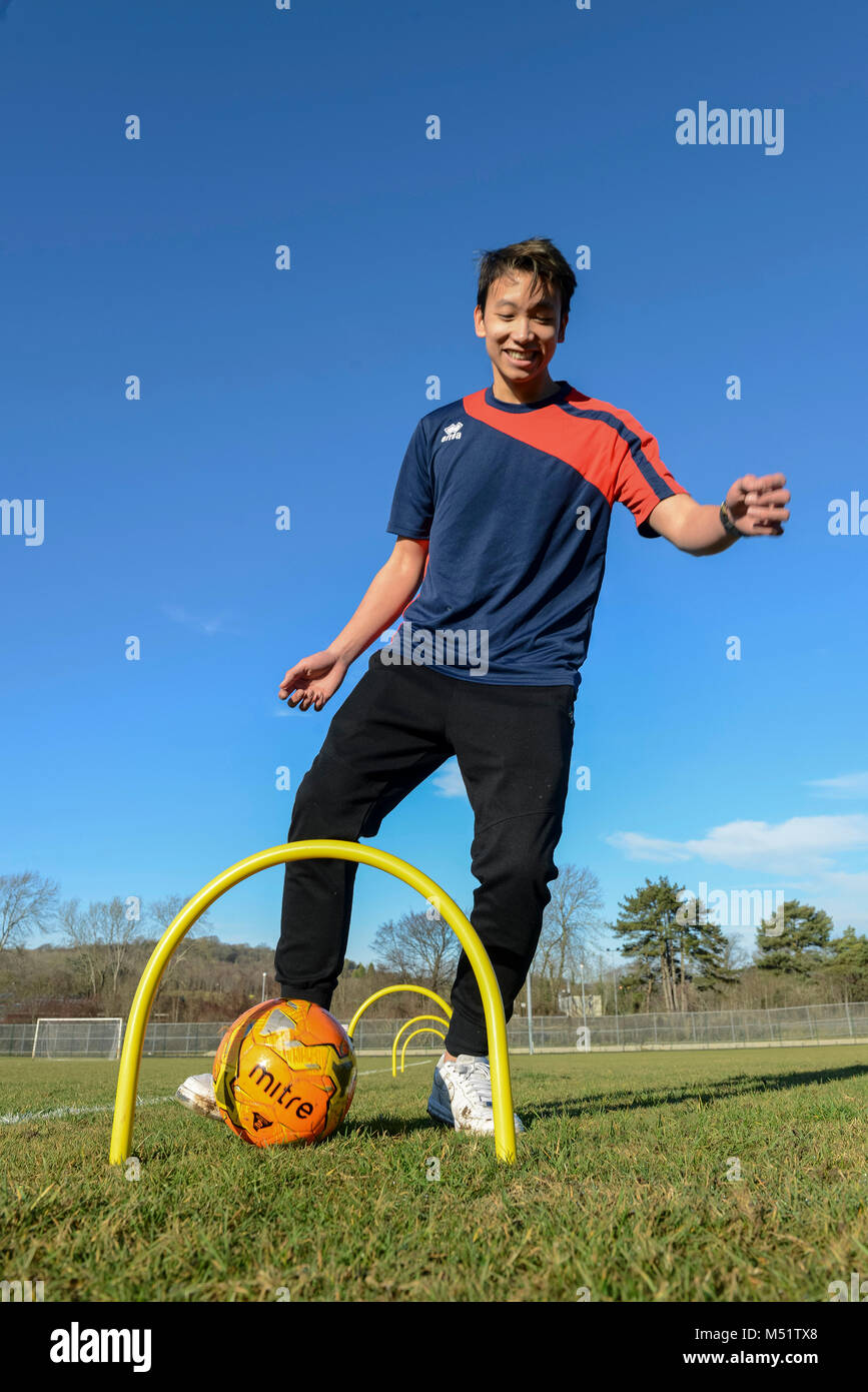 school students having a football lesson to improve their skills at ...