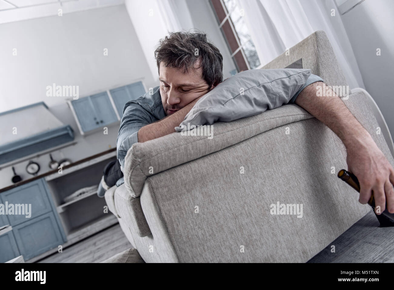 Tired man falling asleep with a bottle after drinking alcohol Stock ...