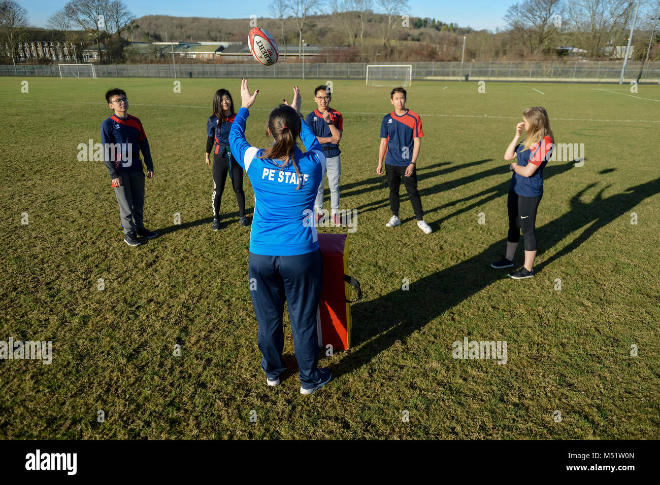 A school PE lesson where the teacher is teaching the college students ...