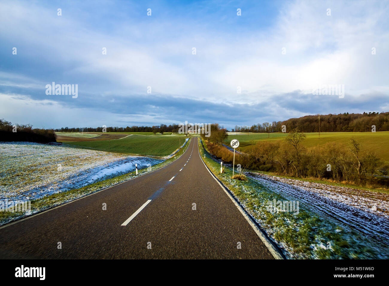 Empty black asphalt road between green fields Stock Photo - Alamy