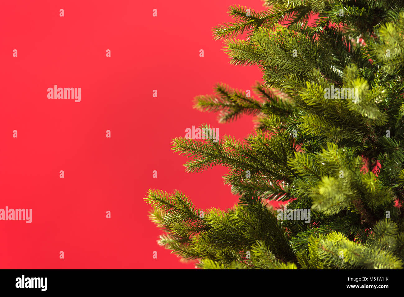 Christmas tree on red background Stock Photo - Alamy