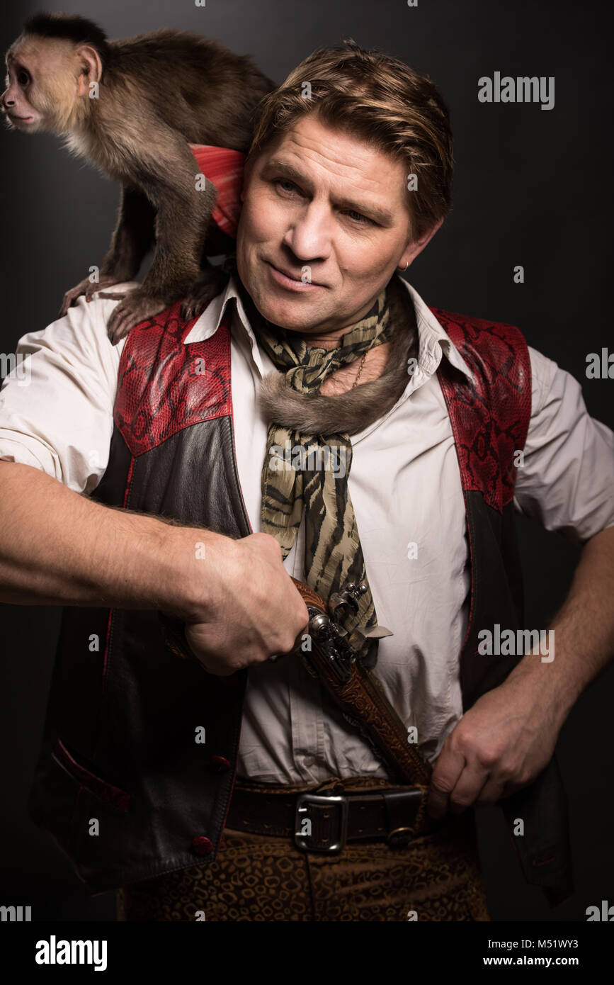 Mature man adventurer in costume of traveler with his monkey companion ...