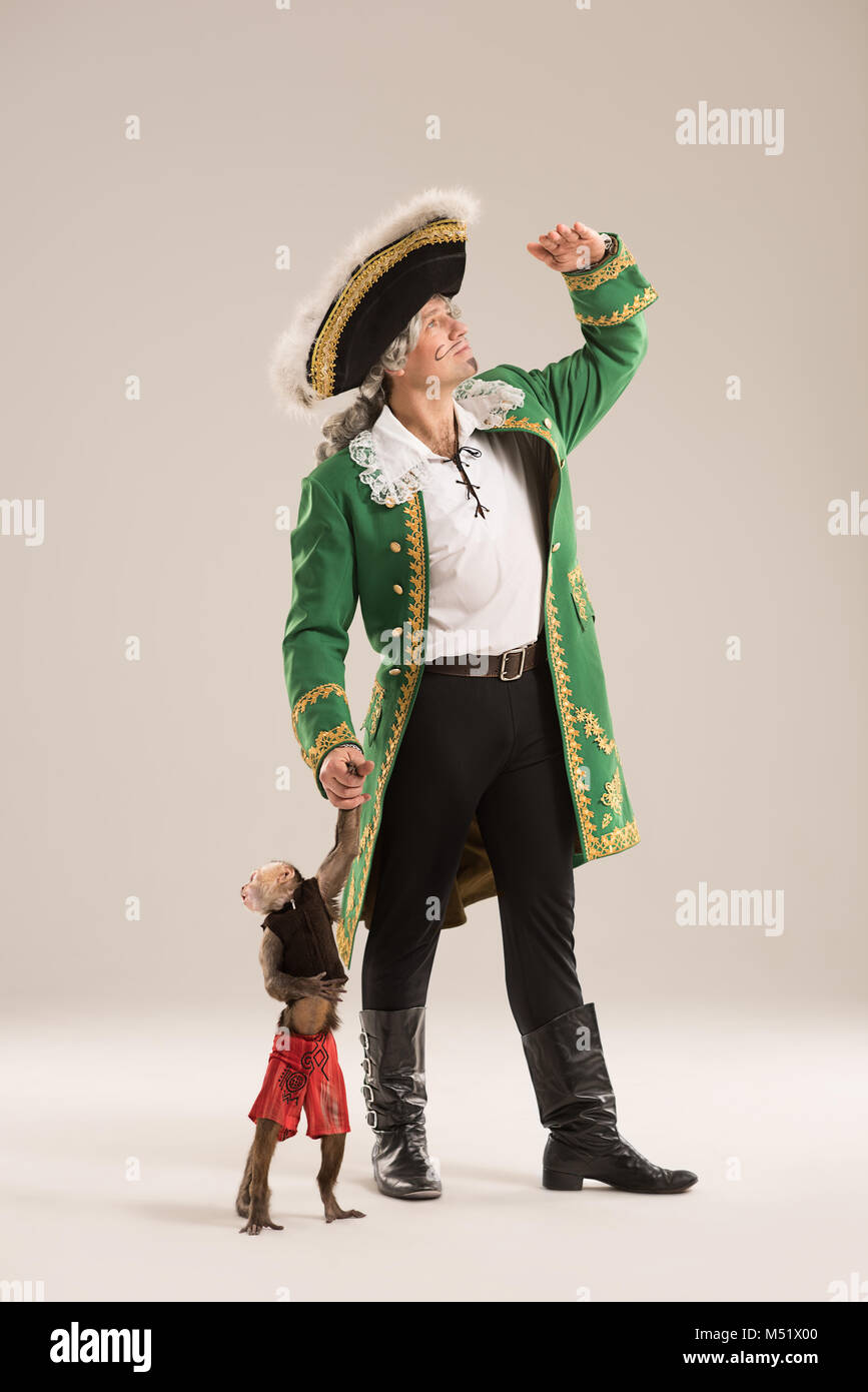 Mature man adventurer in costume of traveler with his monkey companion ...