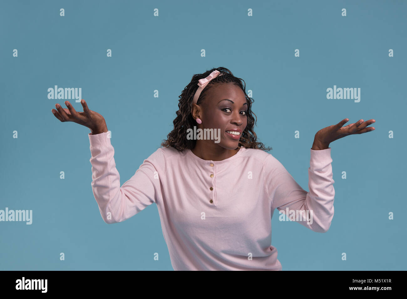 Beautiful African woman making a scale with her arms wide open on blue ...