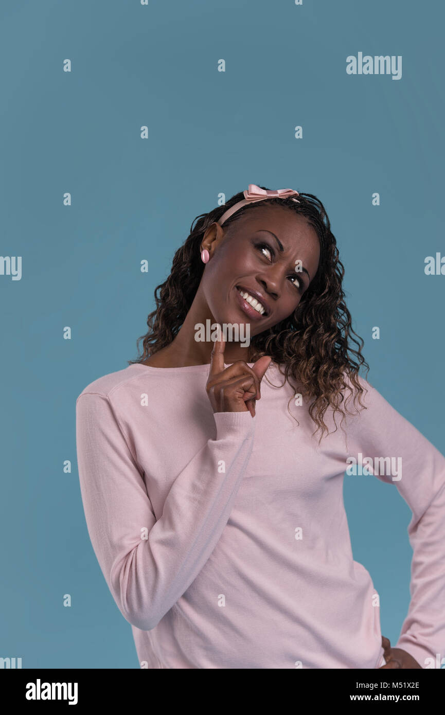 Beautiful young african woman thinking and looking pensive on blue ...
