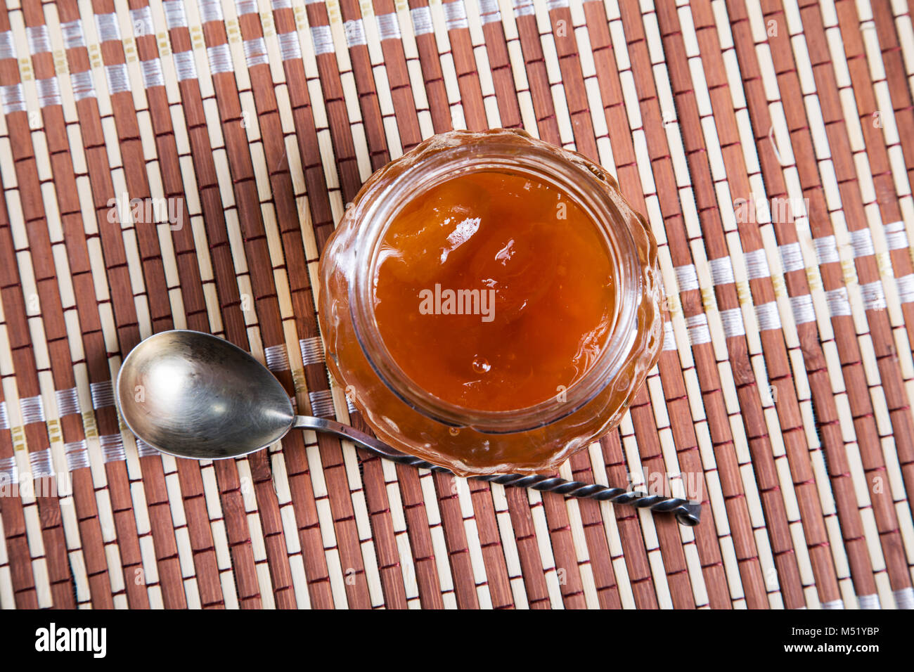 Jam jar with a spoon on a close-up table Stock Photo - Alamy