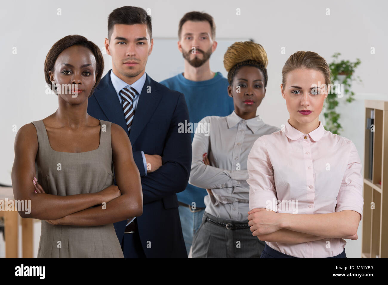 Serious business team standing together at office Stock Photo - Alamy