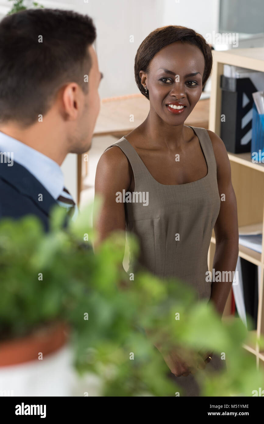Business people of different human races chatting at office together ...