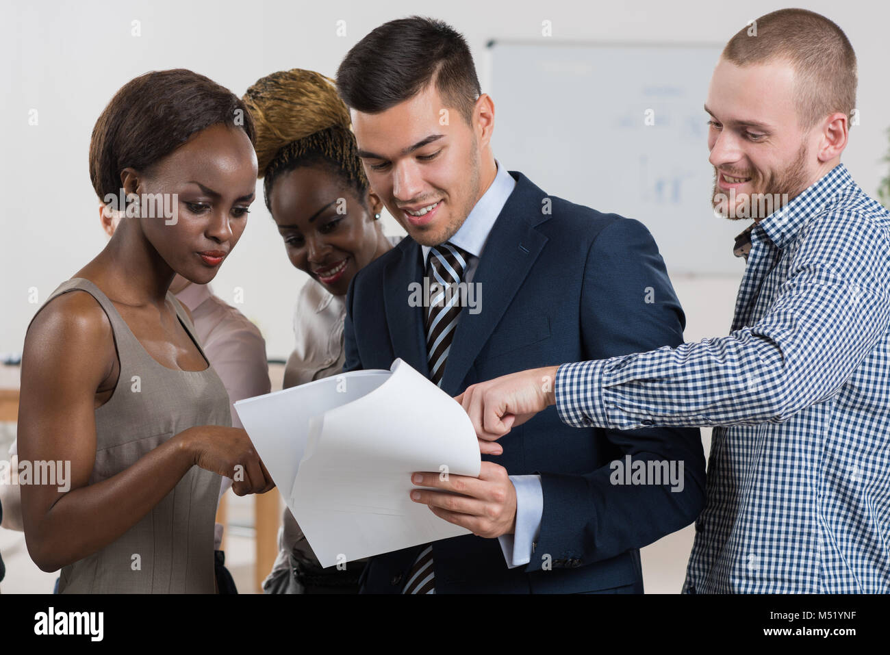 Smiling business team discussing documents and reports at office Stock ...