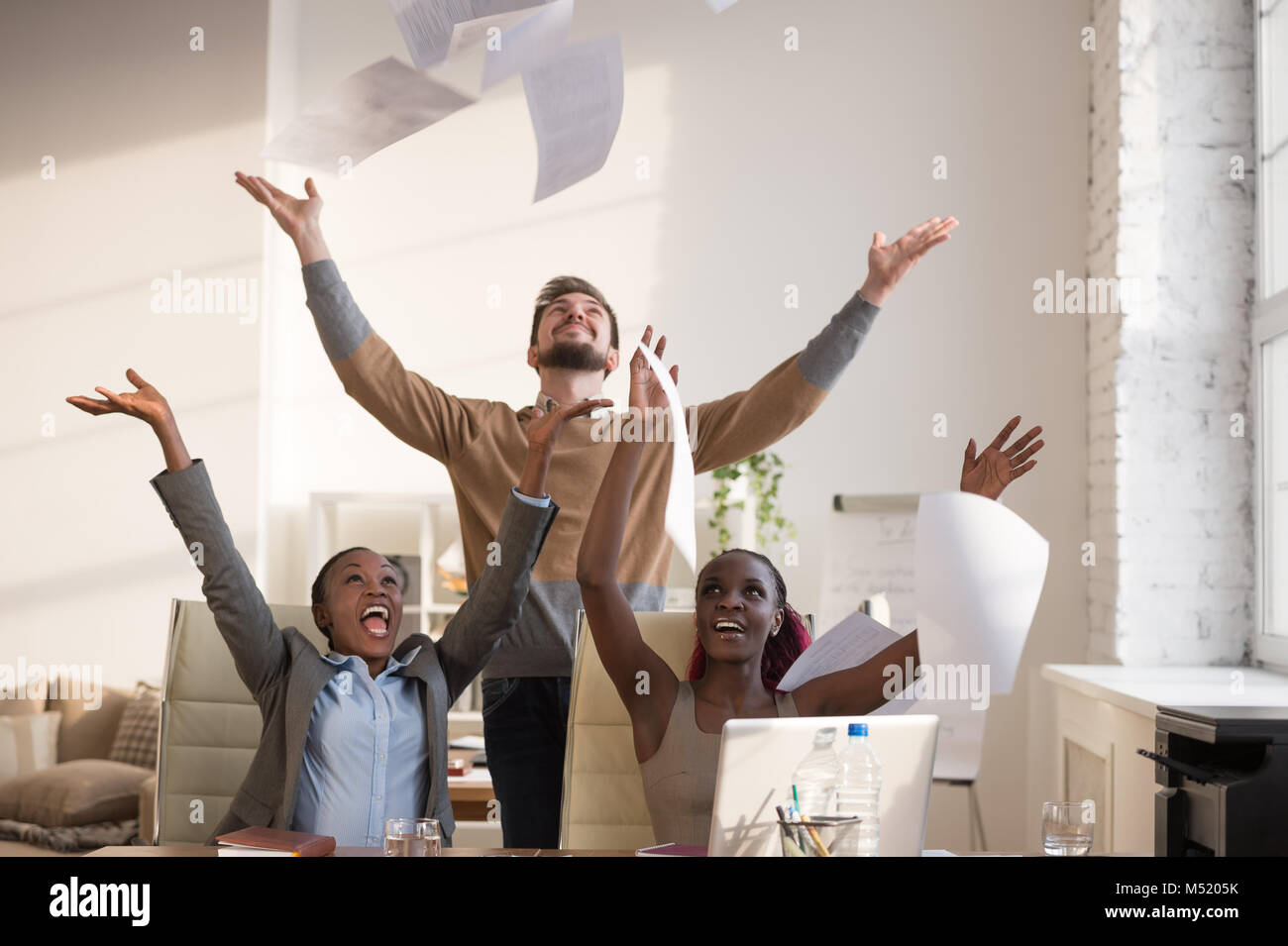Business people excited happy smile, throwing up papers, documents fly ...