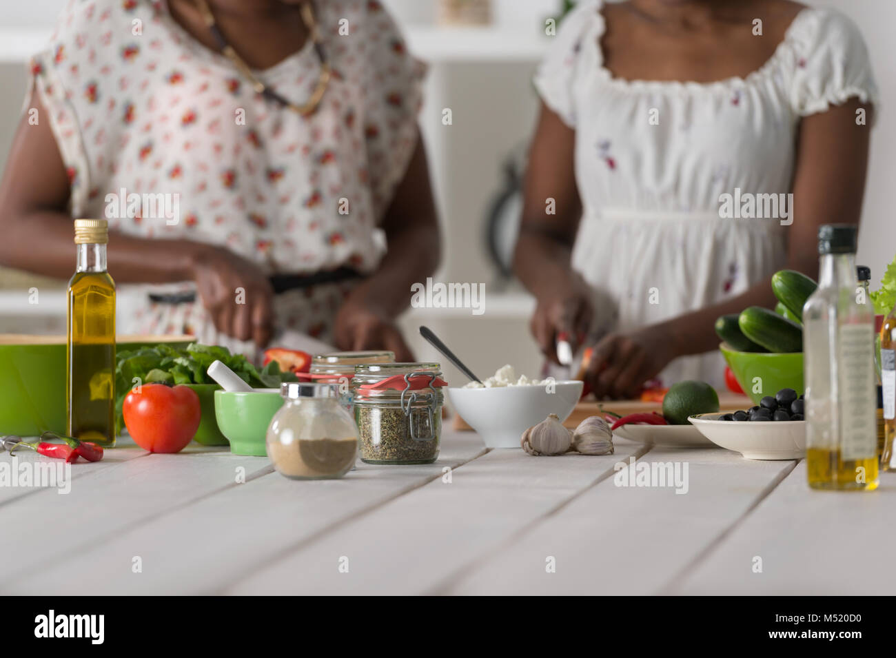 Two unrecognizable african women cooking in kitchen making healthy food ...