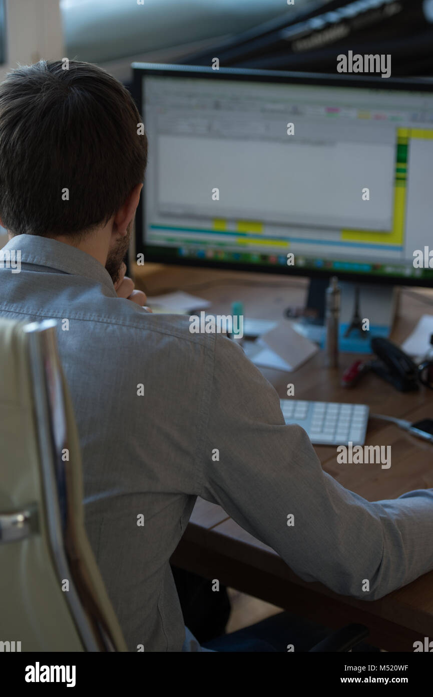 Handsome businessman working with computer in office. Photo from behind ...