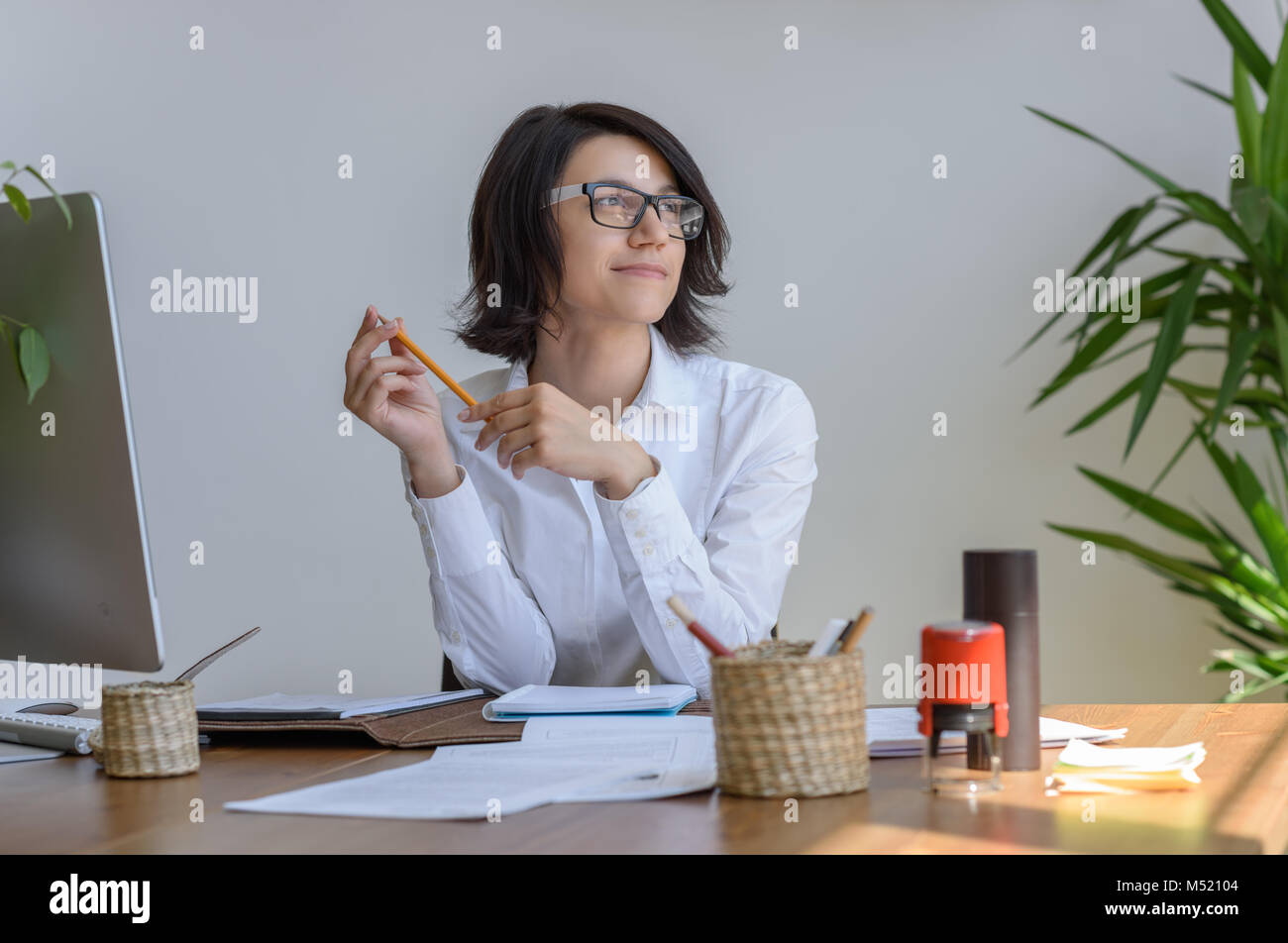 Woman thinking at her workplace Stock Photo - Alamy